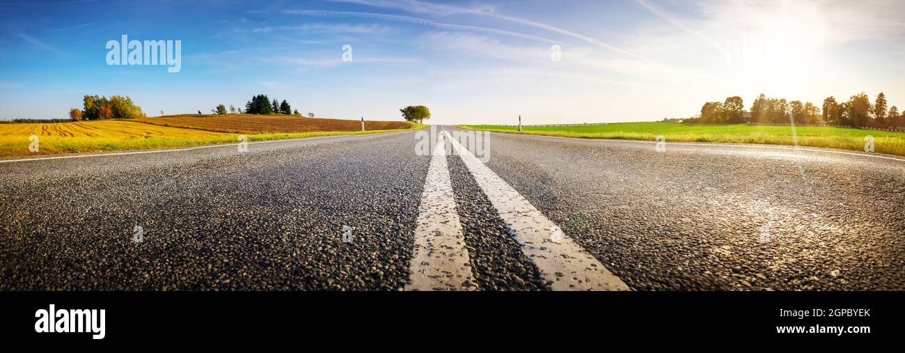 Wide asphalt road panorama in countryside on summer day. Route with ...