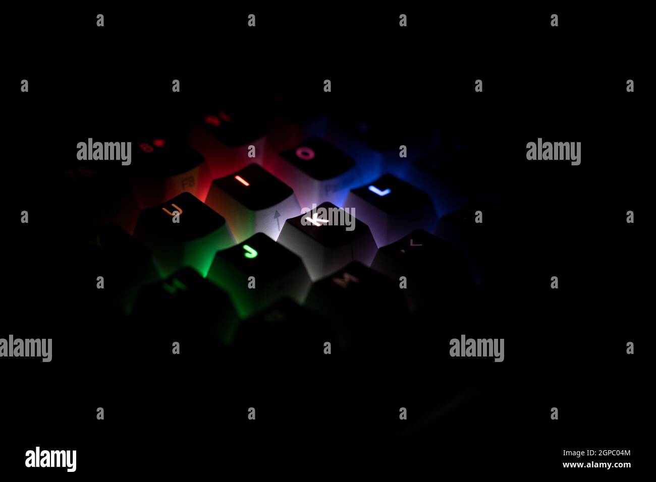 side view detail closeup of illuminated RGB keycaps keys on black on ...