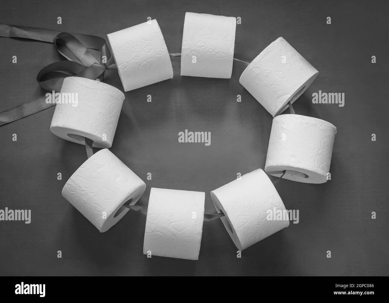 Rolls of white toilet paper are connected with a ribbon in a bundle ...