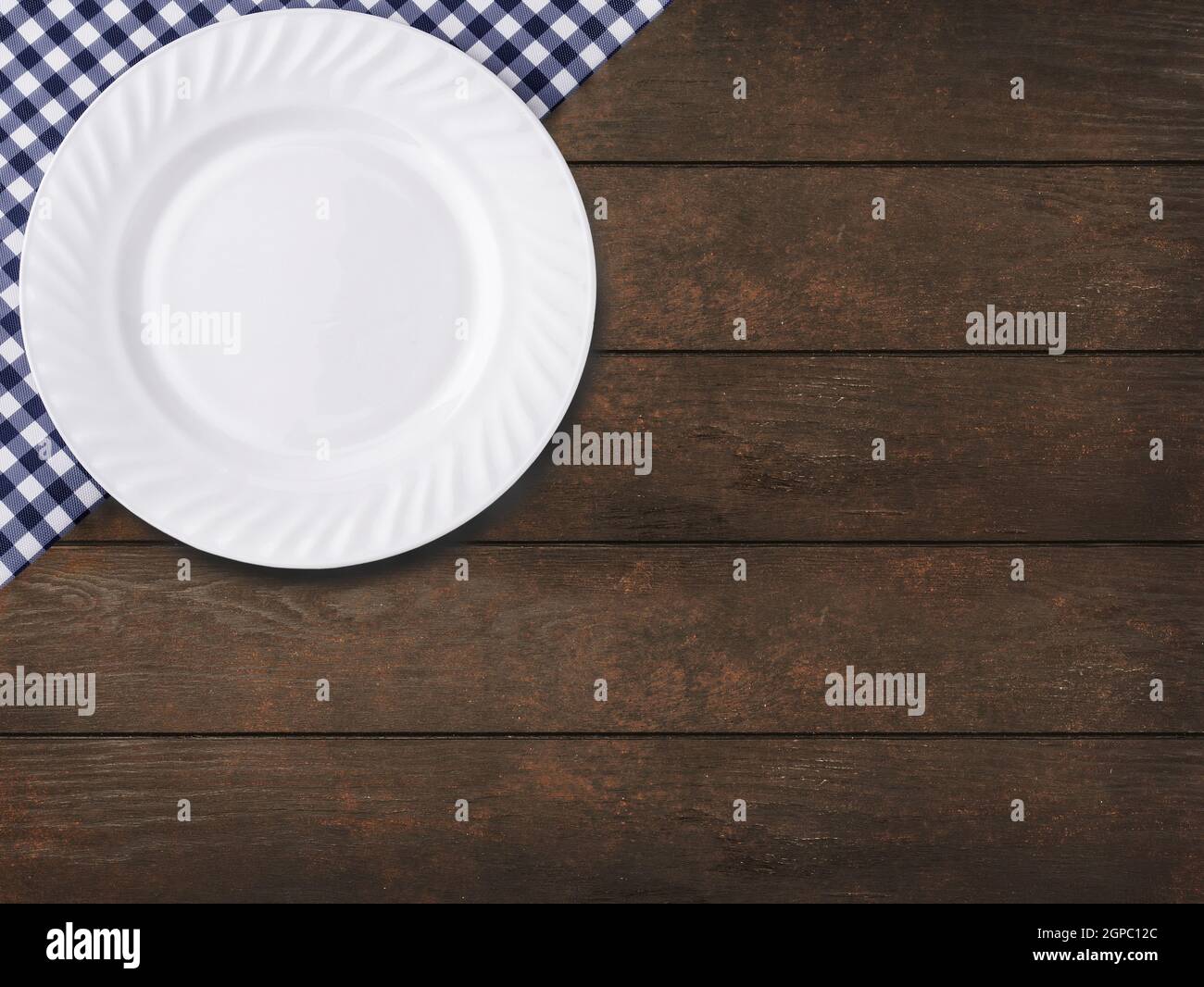 The Blue tablecloth on cage and empy plate on wooden table background ...