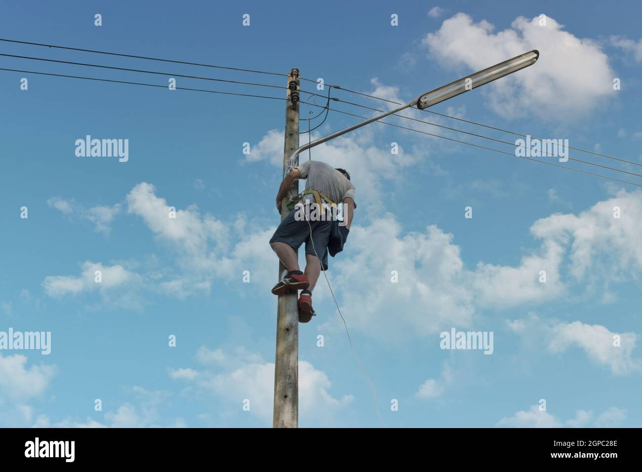 Electrician, repairman are climbing and work on electric pole. Concept ...