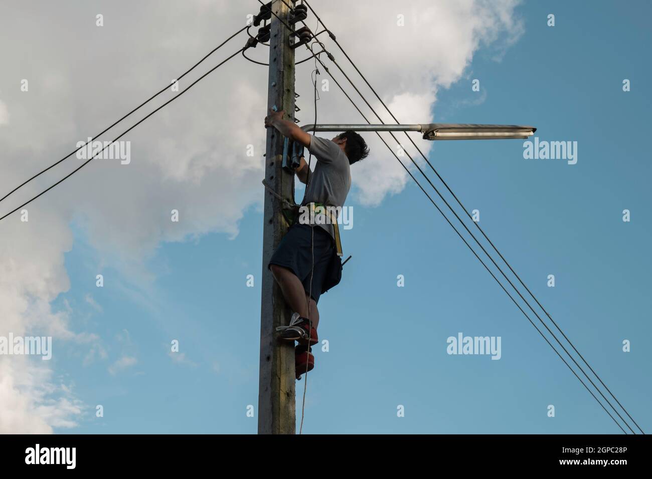 Electrician, repairman are climbing and work on electric pole. Concept ...