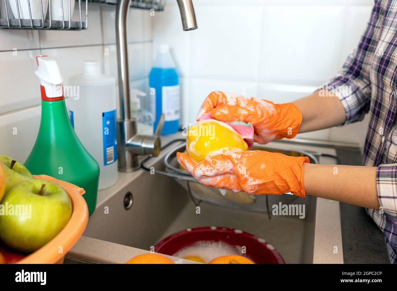 Washing and sanitizing fruits in the kitchen with water and soap. COVID ...