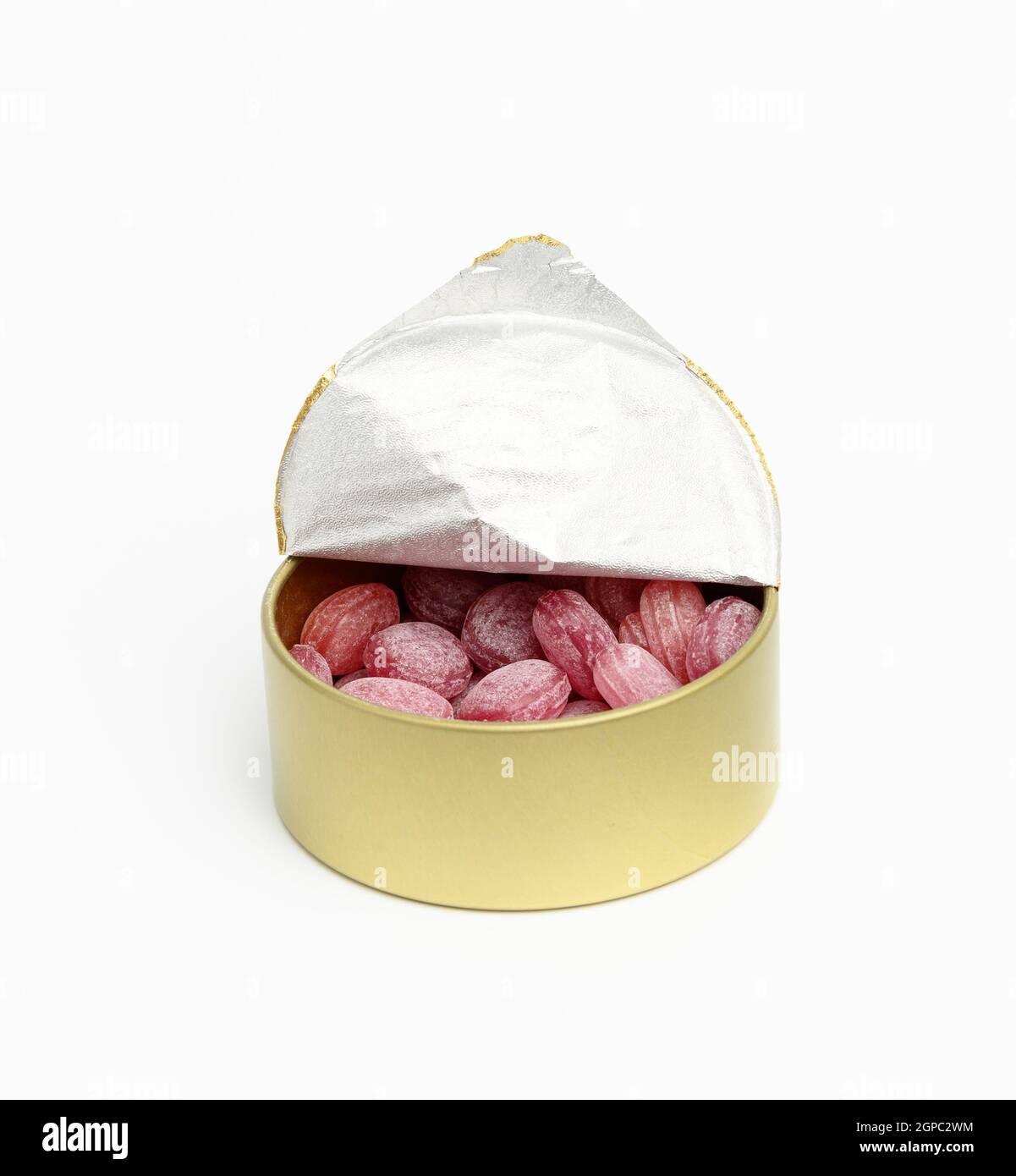 fruit oval lollipops in an open round tin can on a white background ...