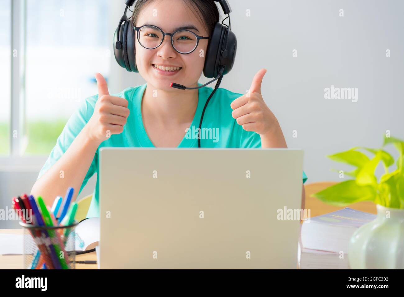 Portrait Asian young woman student glasses headphones happy study smile ...