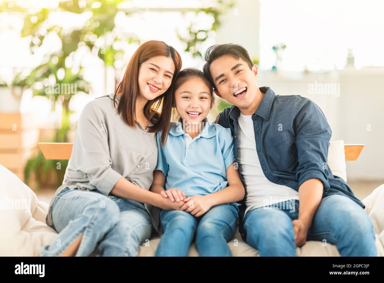 Happy family smiling and hugging on the couch at home Stock Photo - Alamy