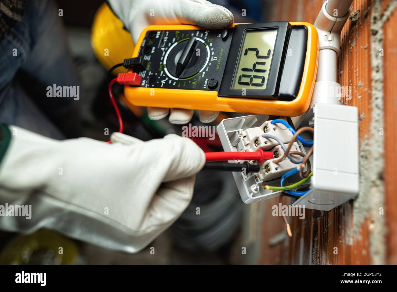 View from above. Electrician worker at work with the tester measures ...