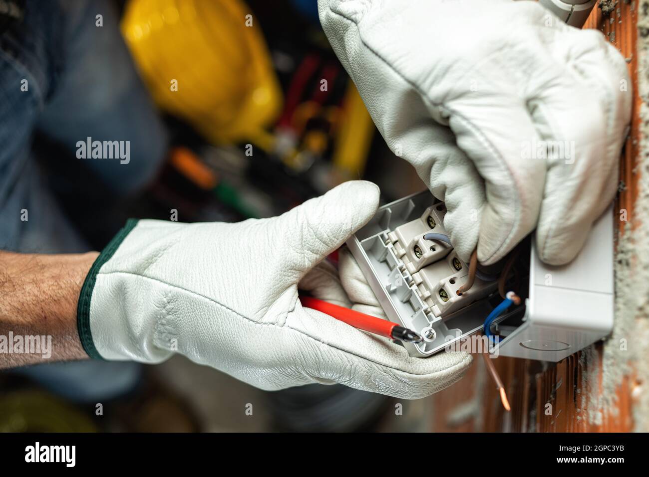 Top view. Electrician worker at work inserts the electrical cable into ...