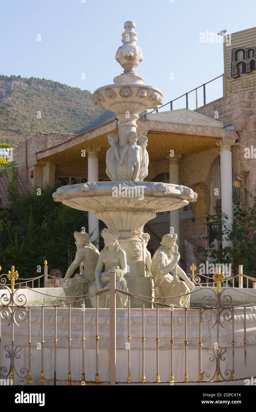Antique fountain at garden. Blue water flowing from stone fountain ...