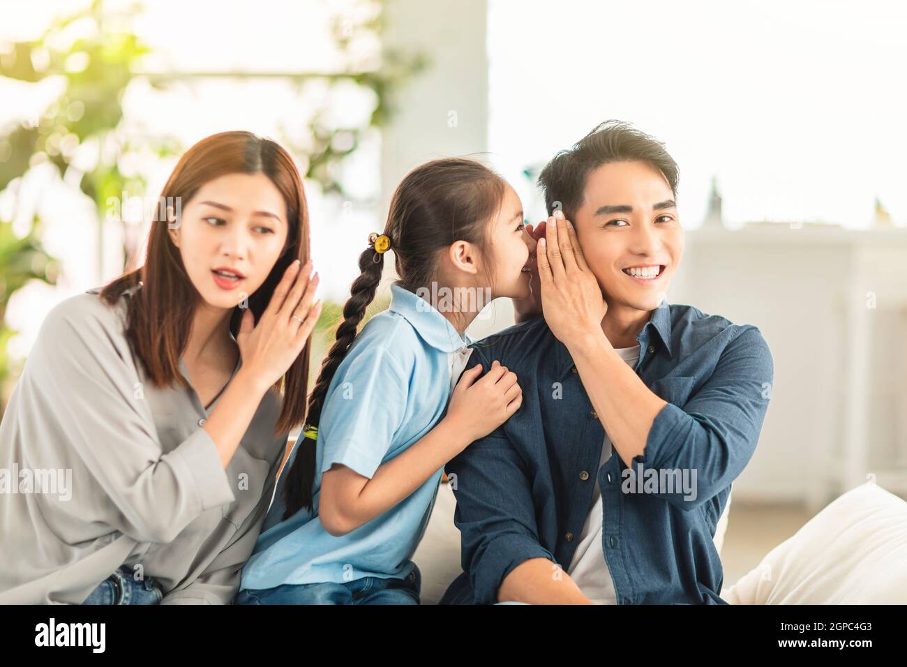 Happy family and child whispering gossip Stock Photo - Alamy