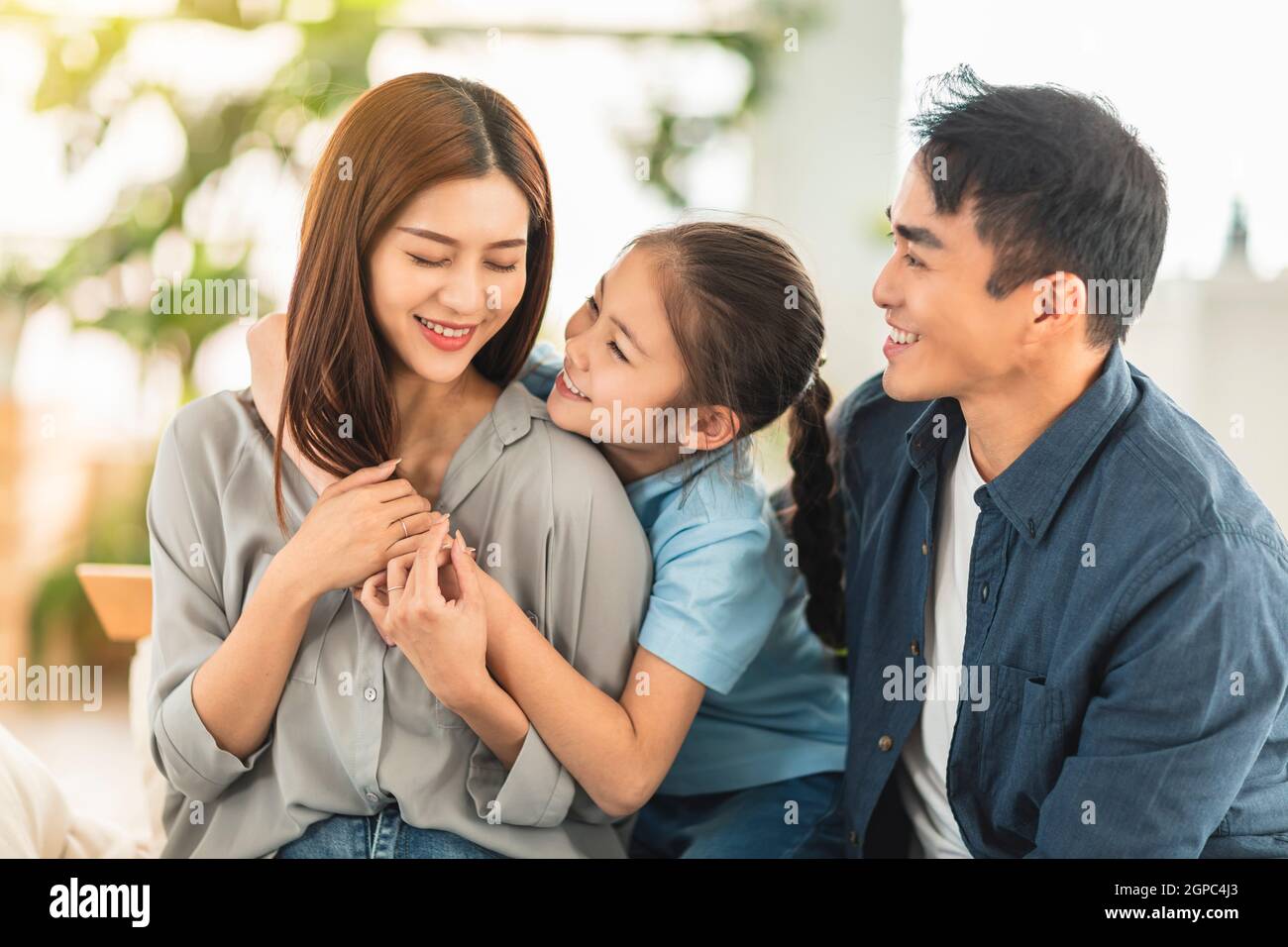 Happy family smiling and hugging on the couch at home Stock Photo - Alamy