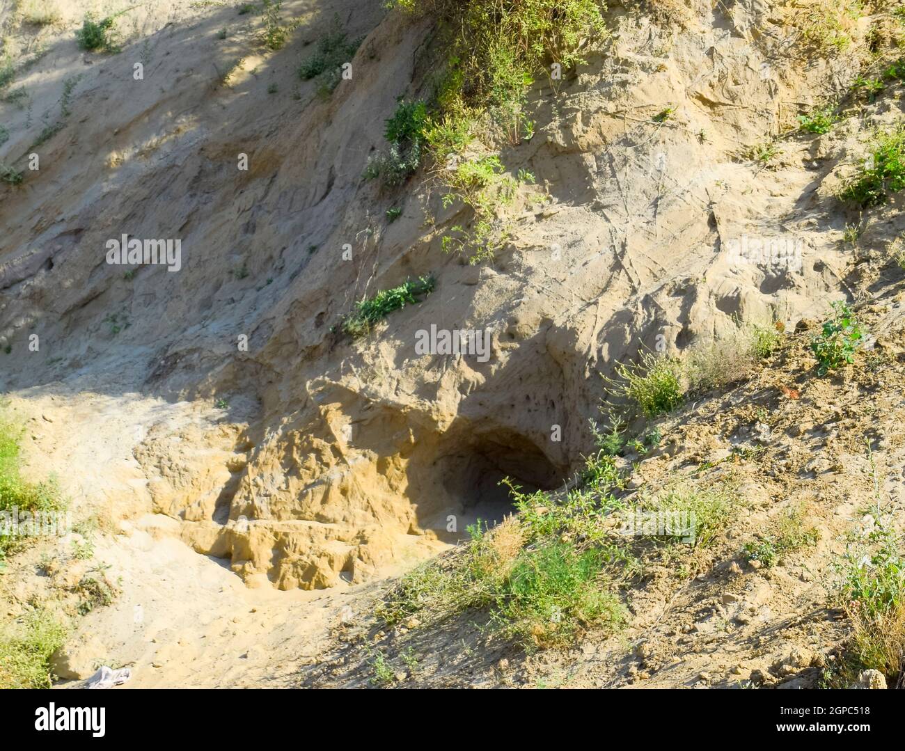 Dug a hole in the cliff for clay extraction Stock Photo - Alamy