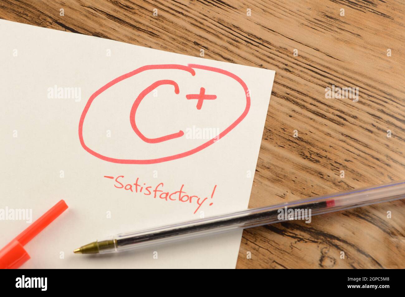 A graded school paper marked in red ink over a wood desktop Stock Photo ...
