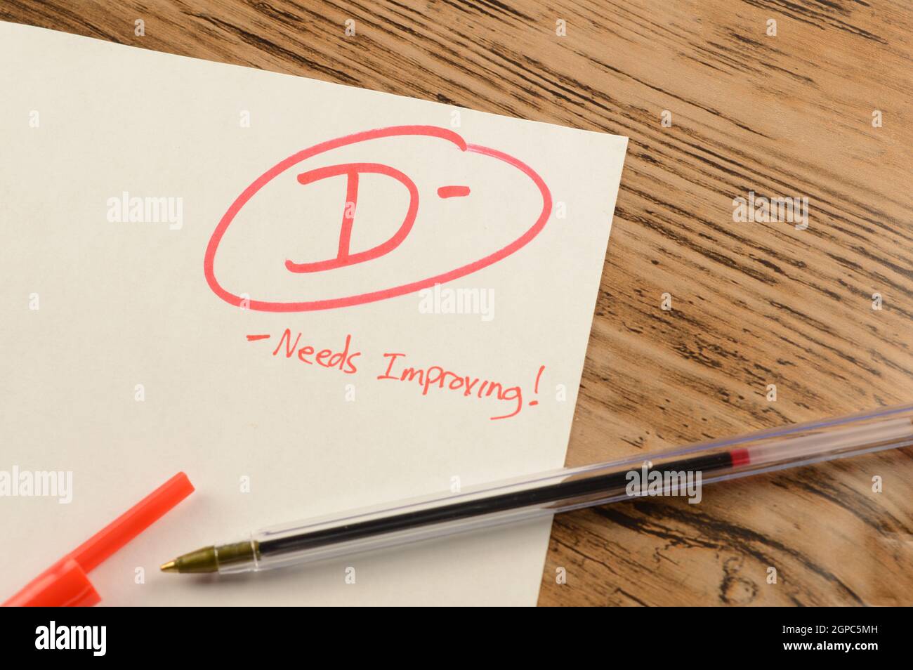 A graded school paper marked in red ink over a wood desktop Stock Photo ...
