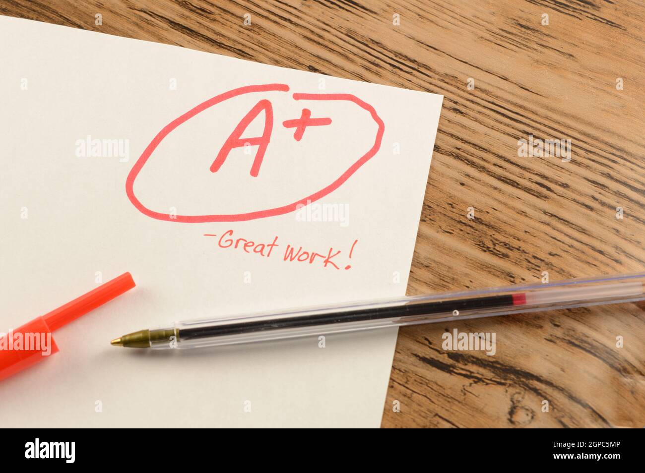 A graded school paper marked in red ink over a wood desktop Stock Photo ...