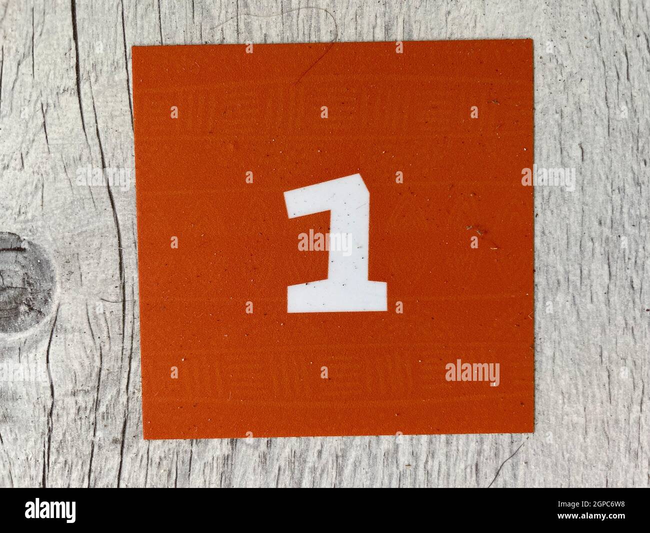 Number one on a orange square card on a wooden surface Stock Photo - Alamy