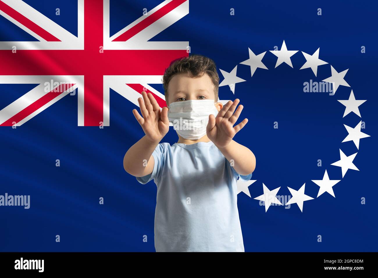 Little white boy in a protective mask on the background of the flag of ...