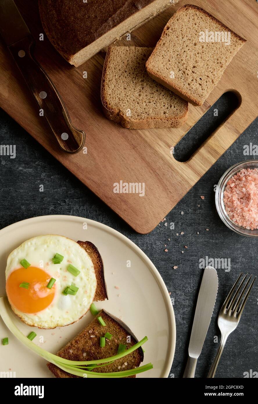 Fried egg, rye fried bread slices and pink salt, close up, top view Stock Photo - Alamy
