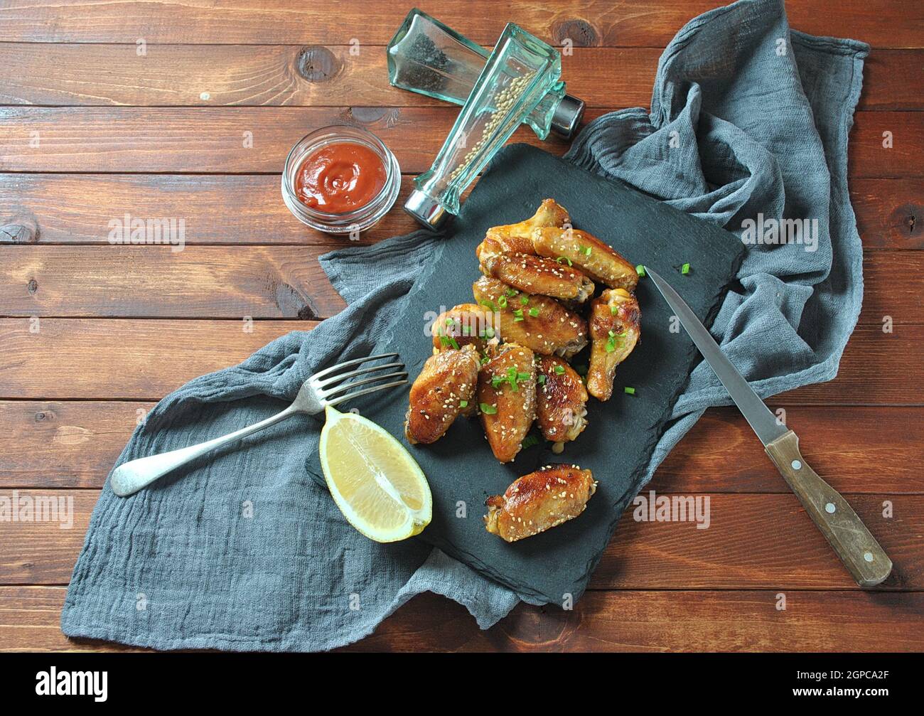 Fried barbecue chicken wings close up on wooden tray shot with selective focus Stock Photo - Alamy
