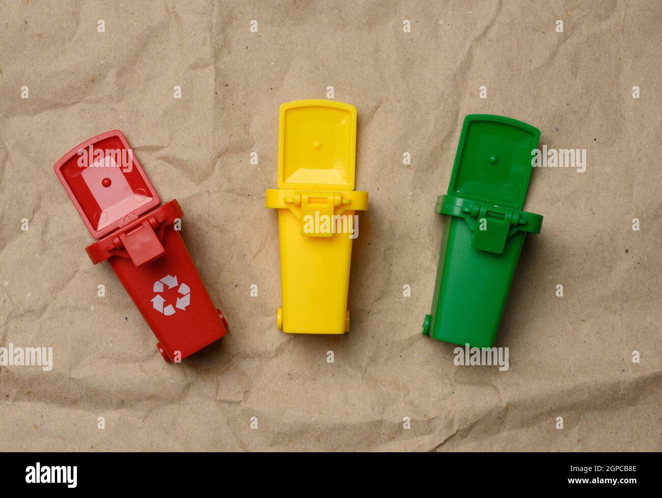 three multi-colored plastic containers on a brown paper background ...