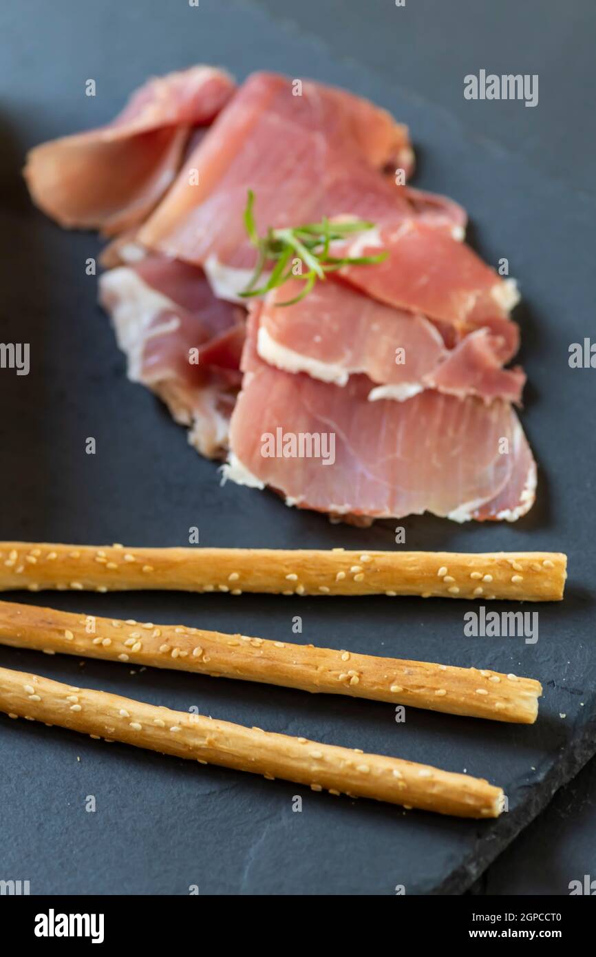 Italian ham served with grissini Stock Photo - Alamy