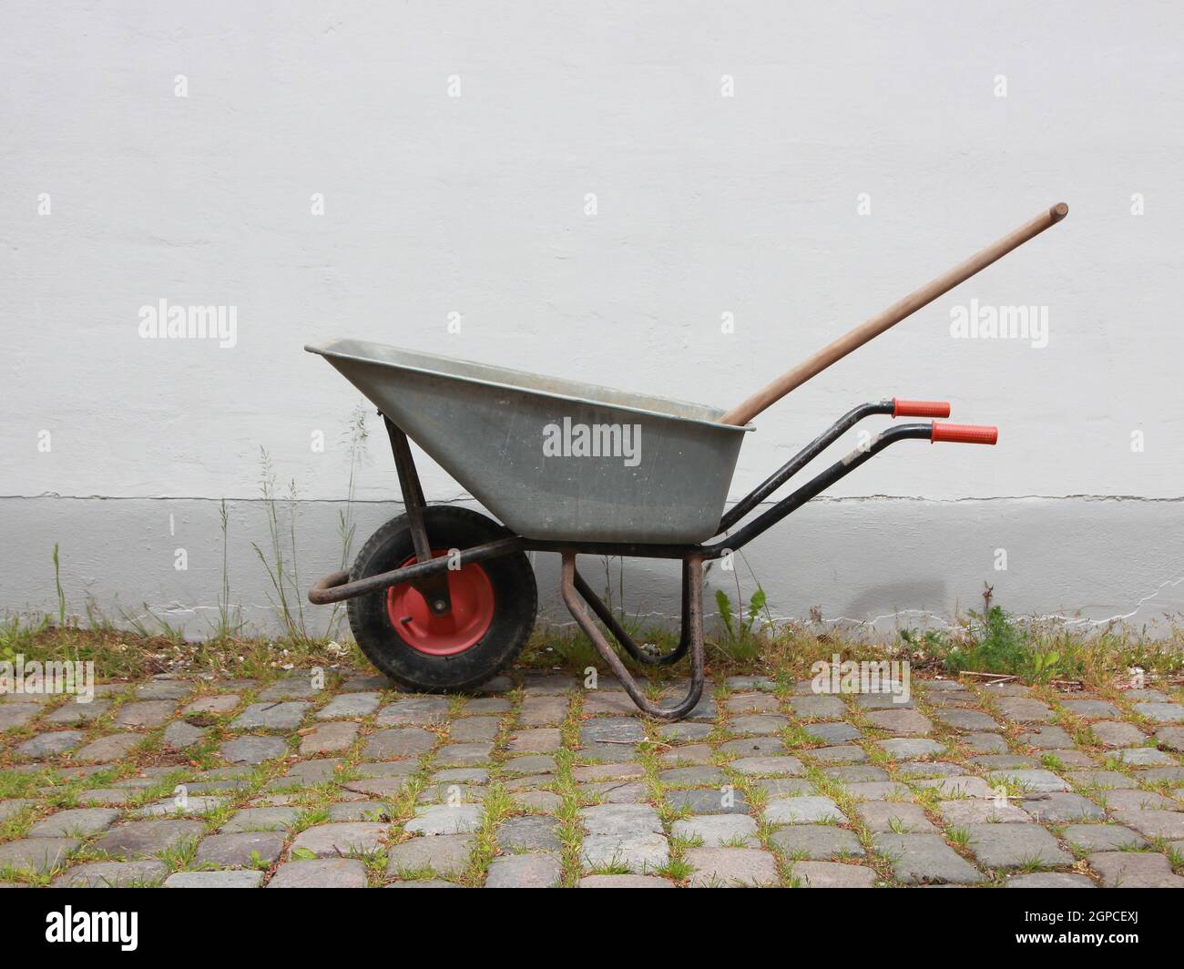 Grey Wheelbarrow with Red Wheel on Cobble Stone Surface with Background ...