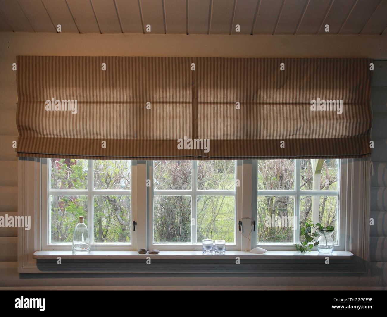 A vintage three-part window with a white frame. The windowsill has ...