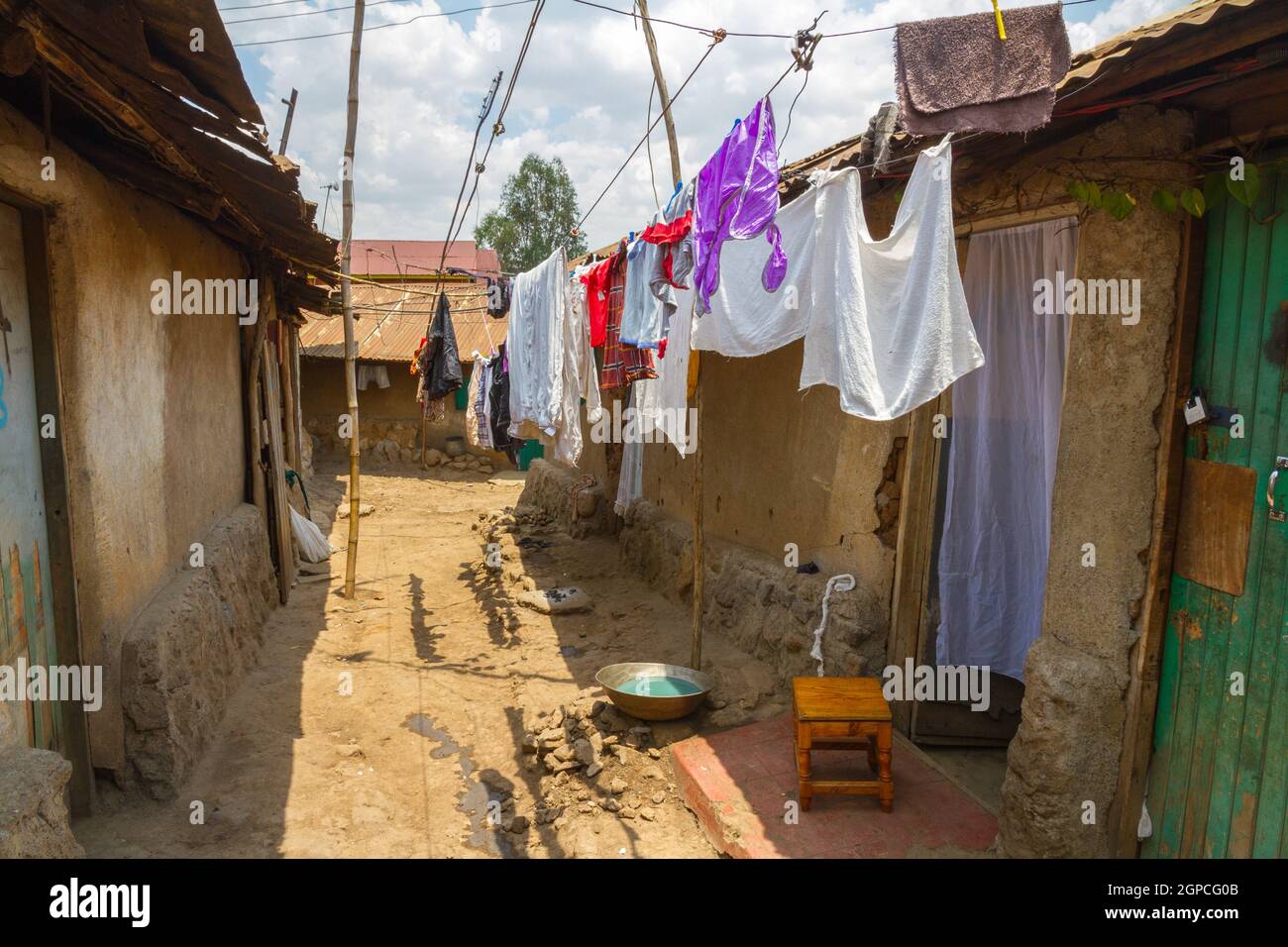 A line of clean clothes dry among the dirty mud and clay homes of the ...