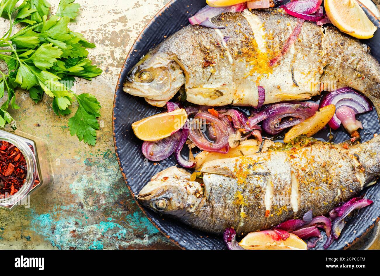 Roasted trout with lemon and onion on plate Stock Photo - Alamy