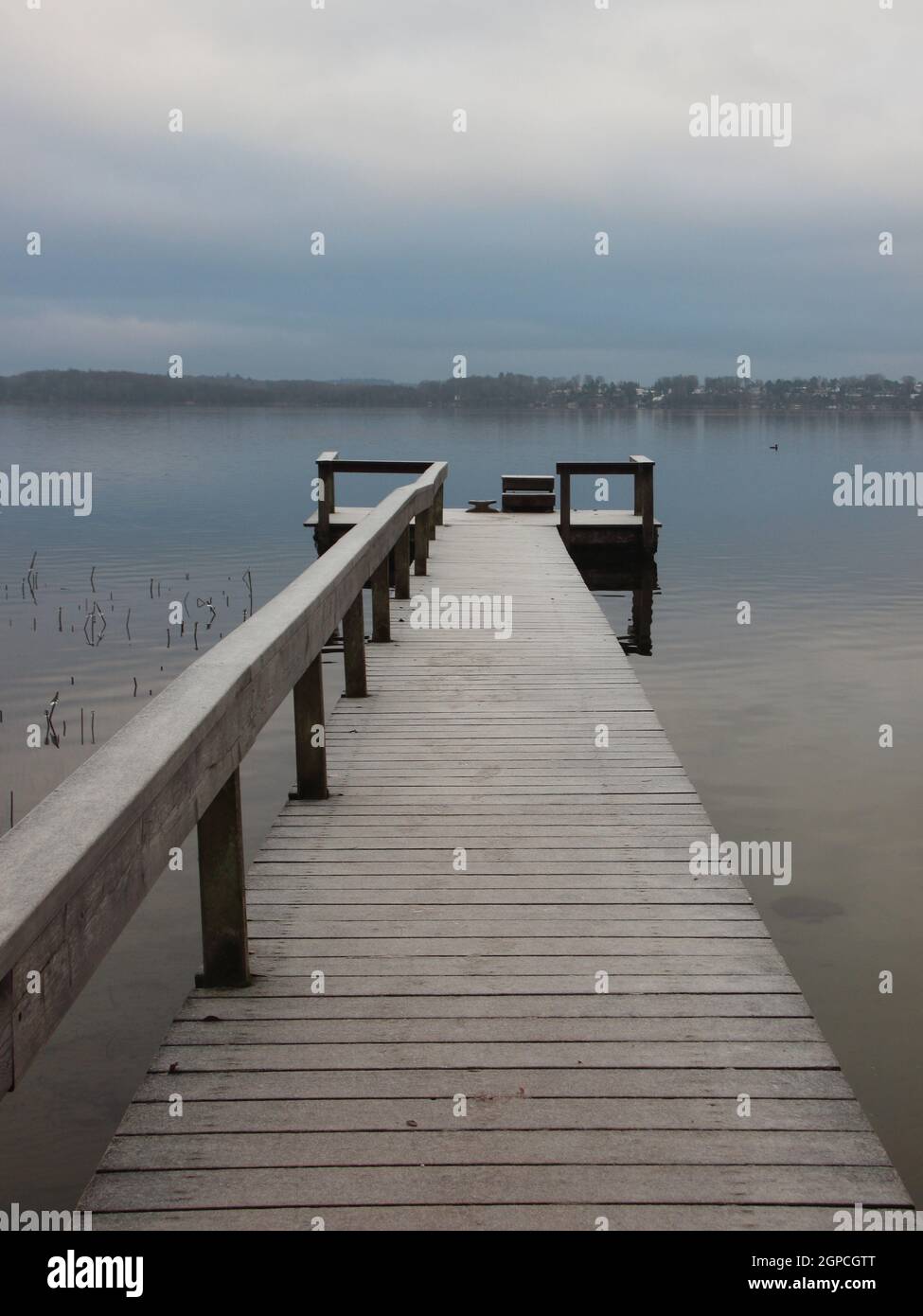 Empty Bathing Pier with wooden railing in winter with Snow and Icy Lake ...