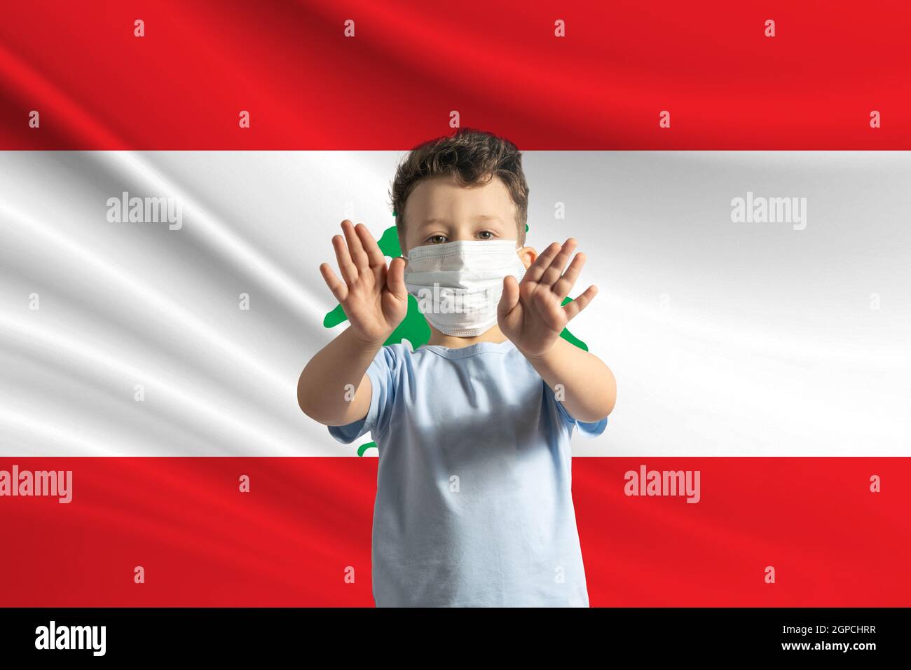 Little white boy in a protective mask on the background of the flag of ...