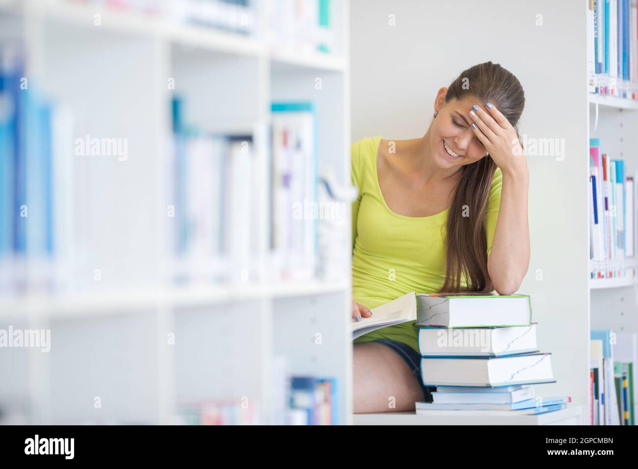Cute female university/highschool student with books in library Stock ...