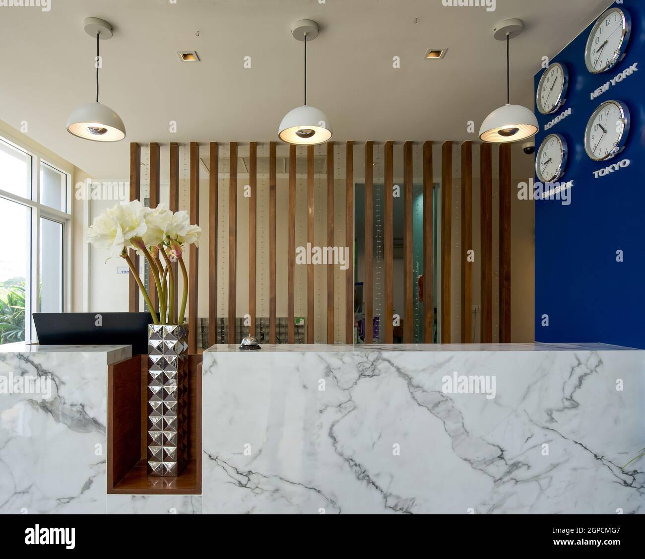 A long white marble reception counter located in the hotel lobby. The ...