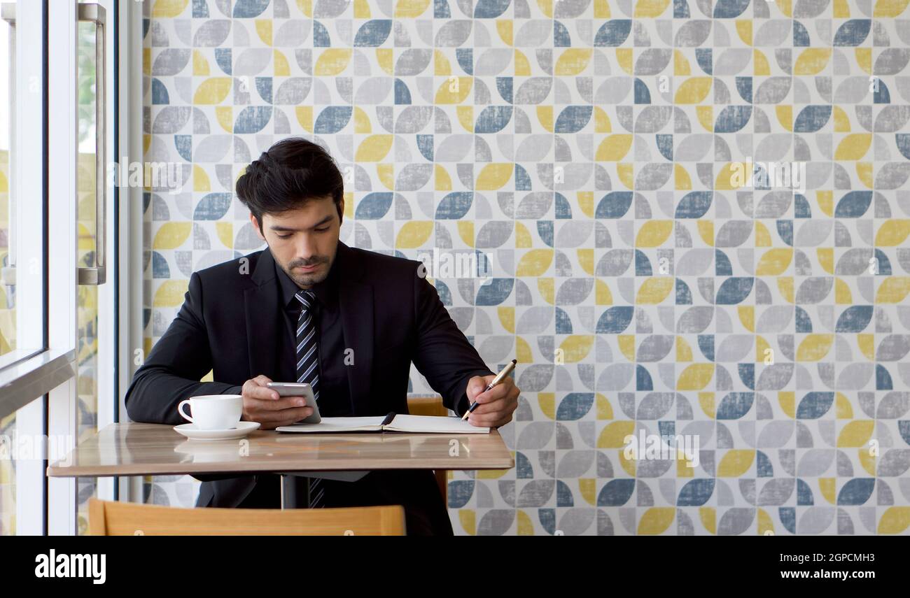 A businessman in a black suit clear the rest of the work during lunch ...