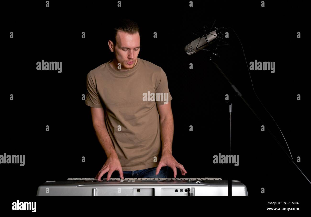 Young caucasian man sing while playing an electric keyboard in front of ...