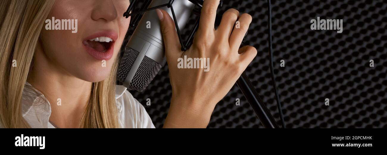 Closeup caucasian female hand and mouth, singing in front of black ...