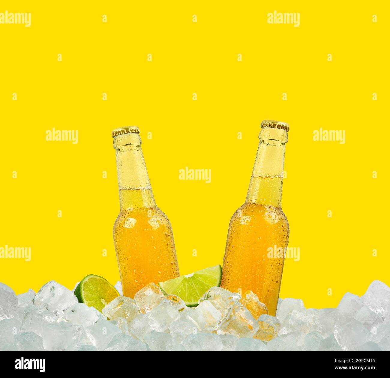Close up two clear glass bottles of cold lager beer on ice cubes at ...