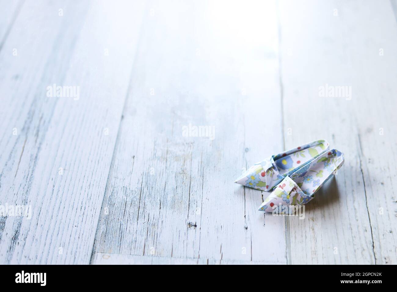 Origami high heels on the white painted wooden table Stock Photo - Alamy