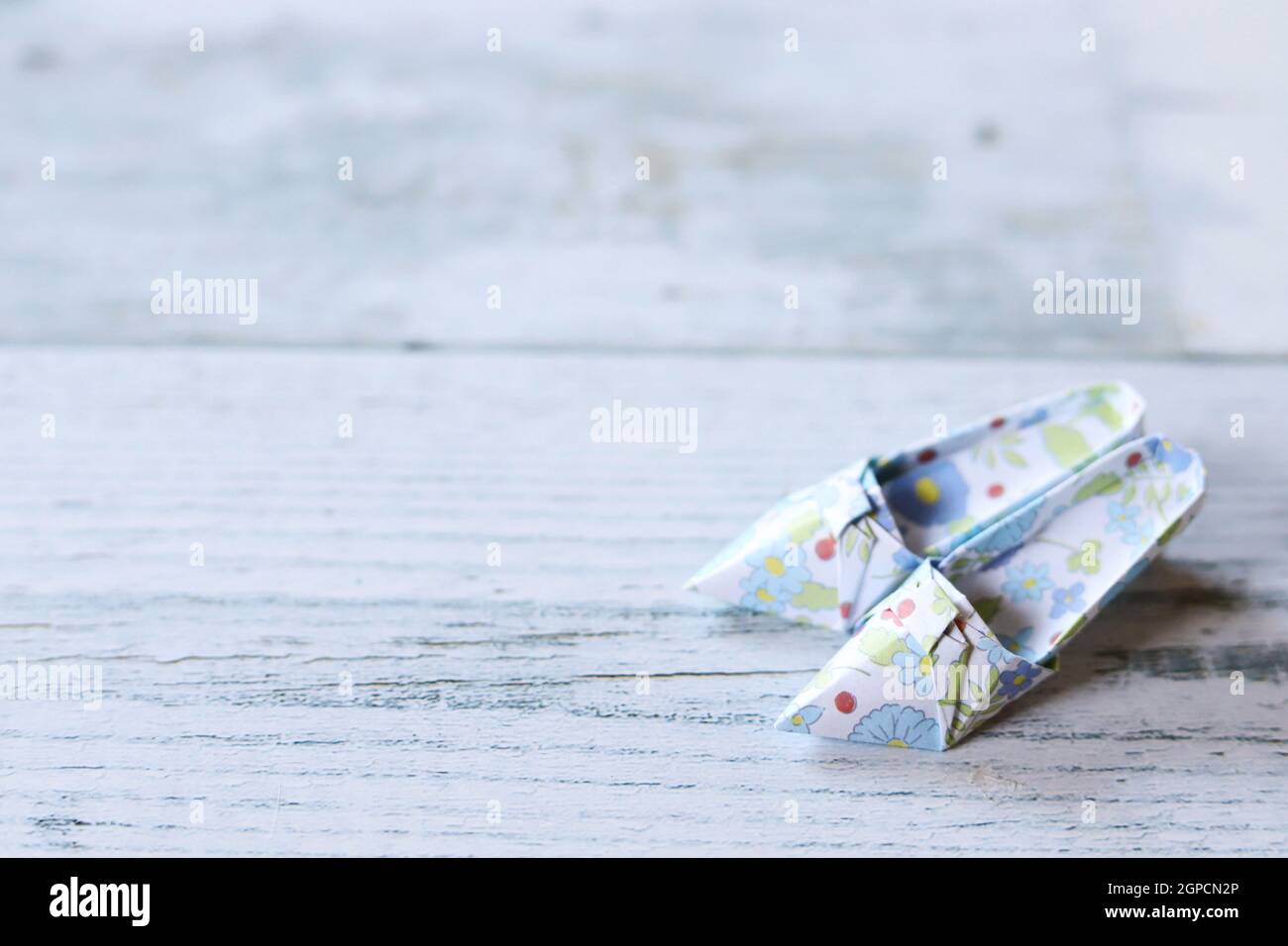 Origami high heels on the white painted wooden table Stock Photo - Alamy