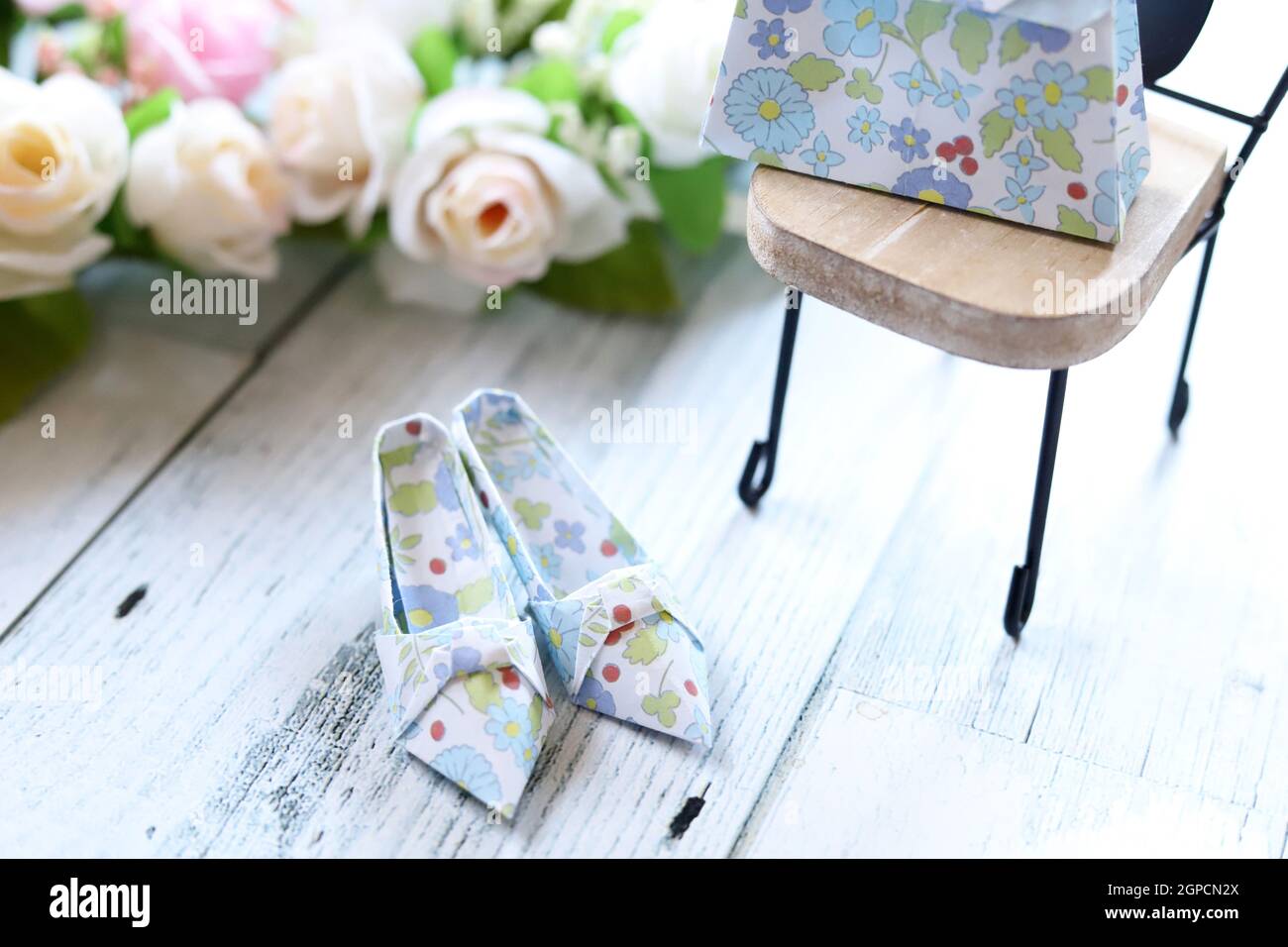 Handmade origami high heels and a handbag on a miniature chair Stock ...