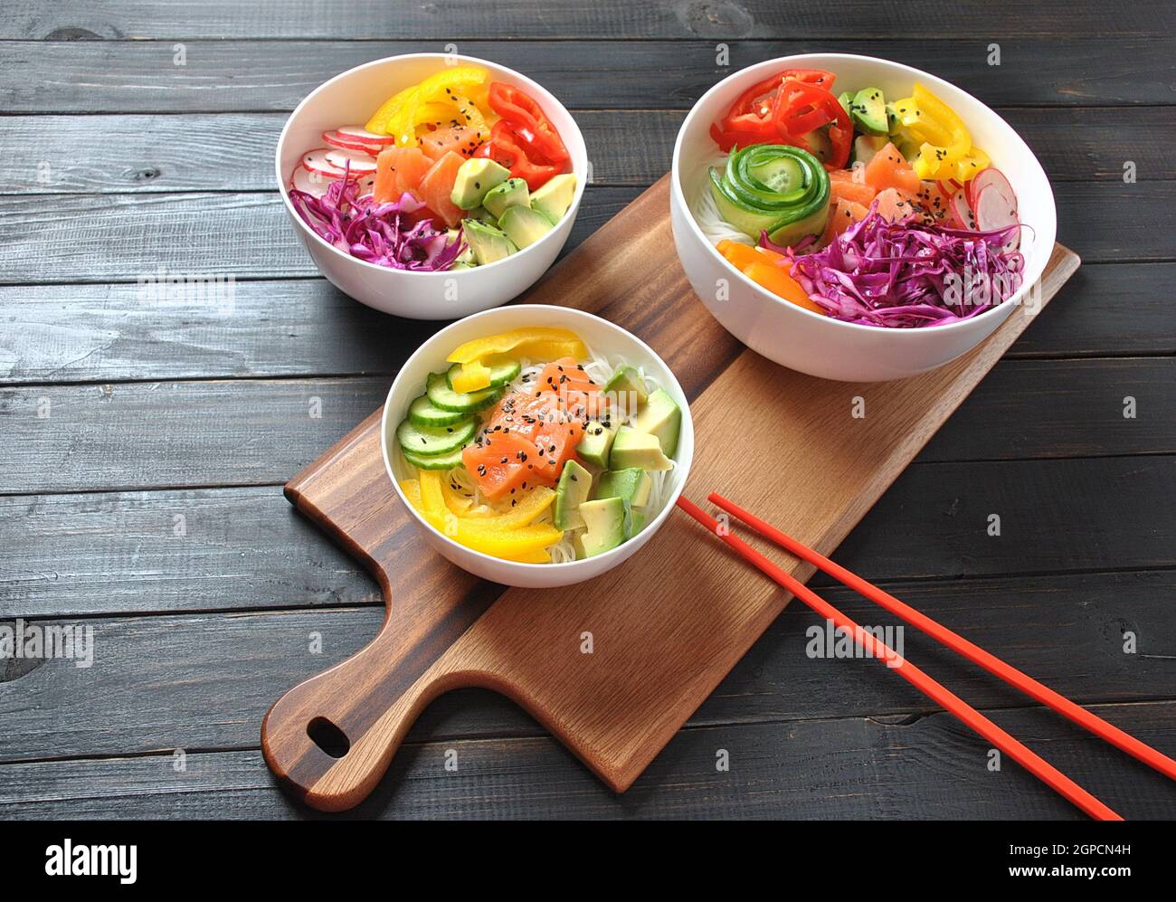 Poke bowls with fresh salmon, crystal noodles, radish, avocado, sweet ...