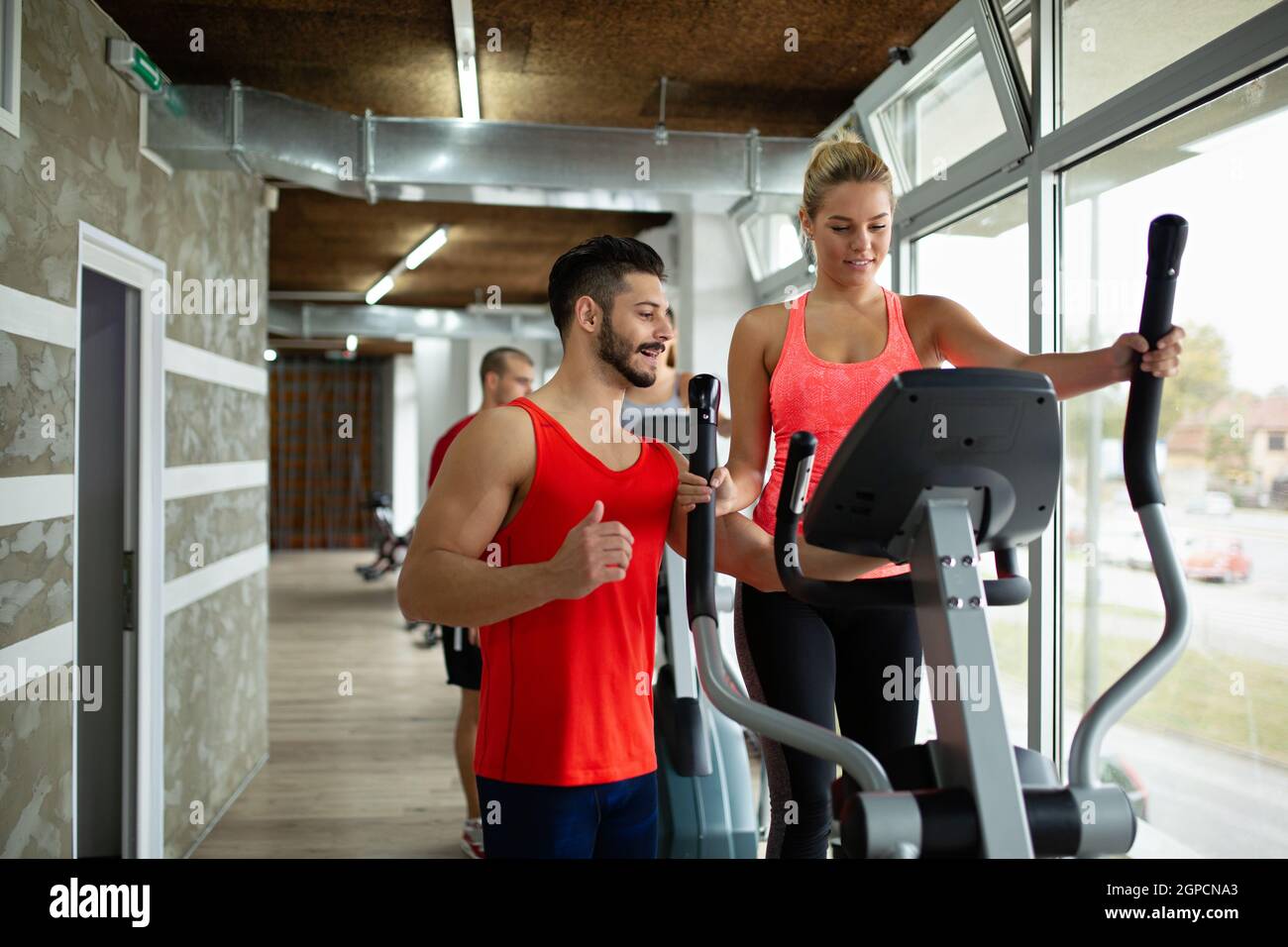 Personal trainer assisting woman to lose weight. Sport exercise people ...