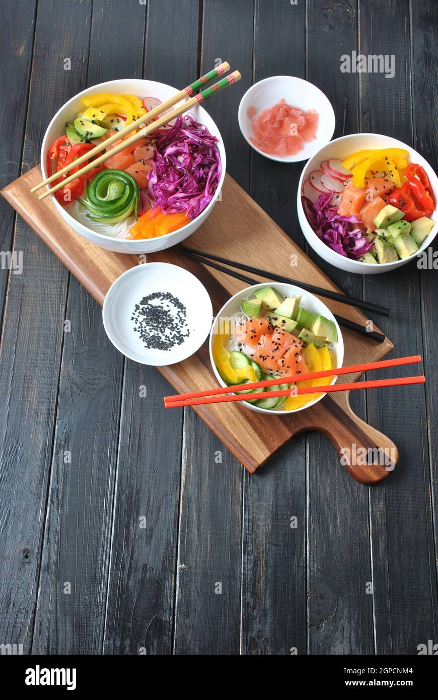 Poke bowls with fresh salmon, crystal noodles, radish, avocado, sweet ...