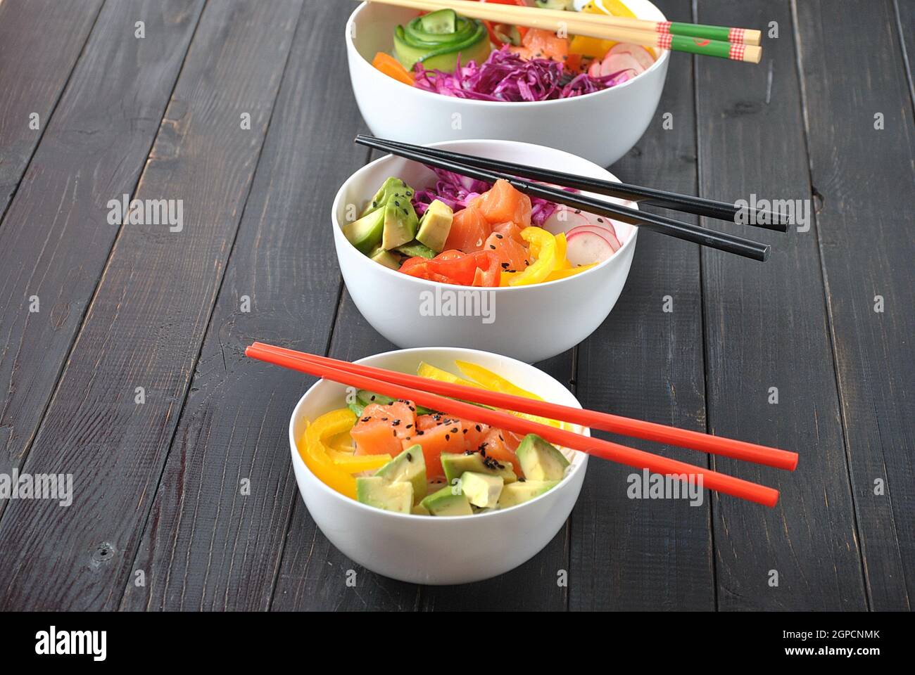 Poke bowls with fresh salmon, crystal noodles, radish, avocado, sweet ...