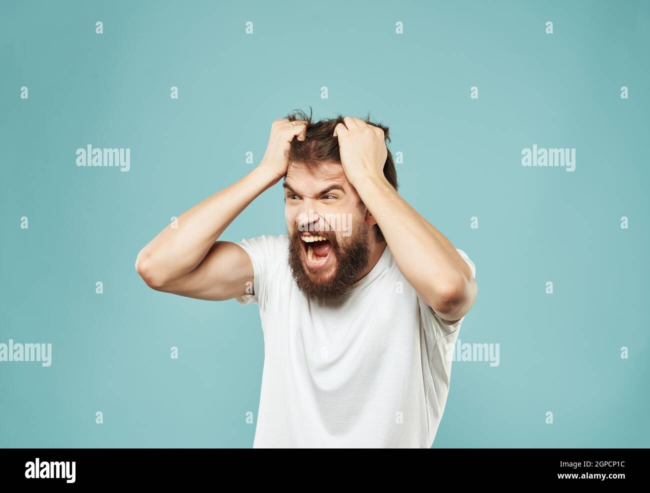 emotional man in a white t-shirt irritated facial expression blue ...