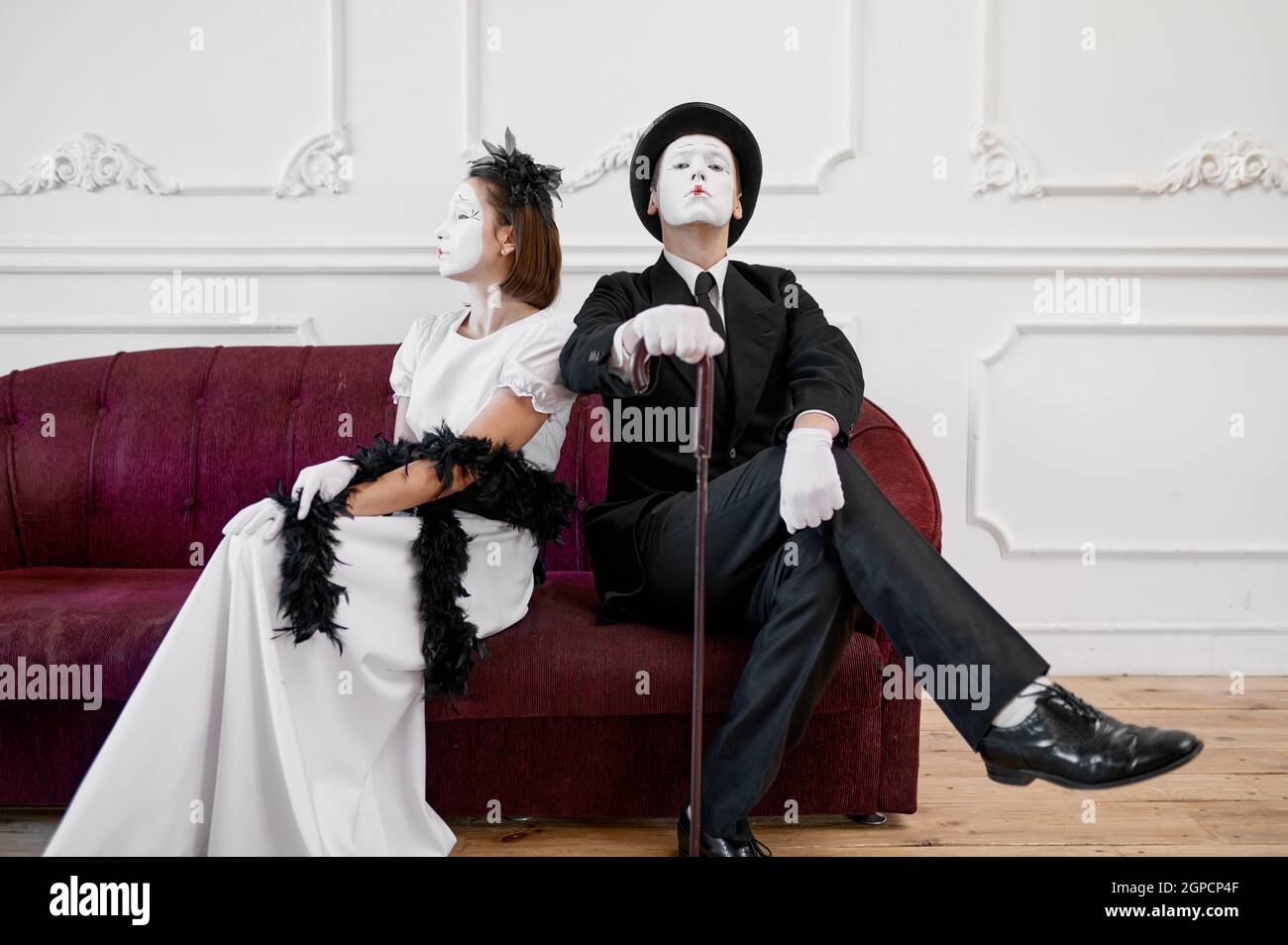 Two mime artists, lady and gentleman sitting on sofa. Pantomime theater ...