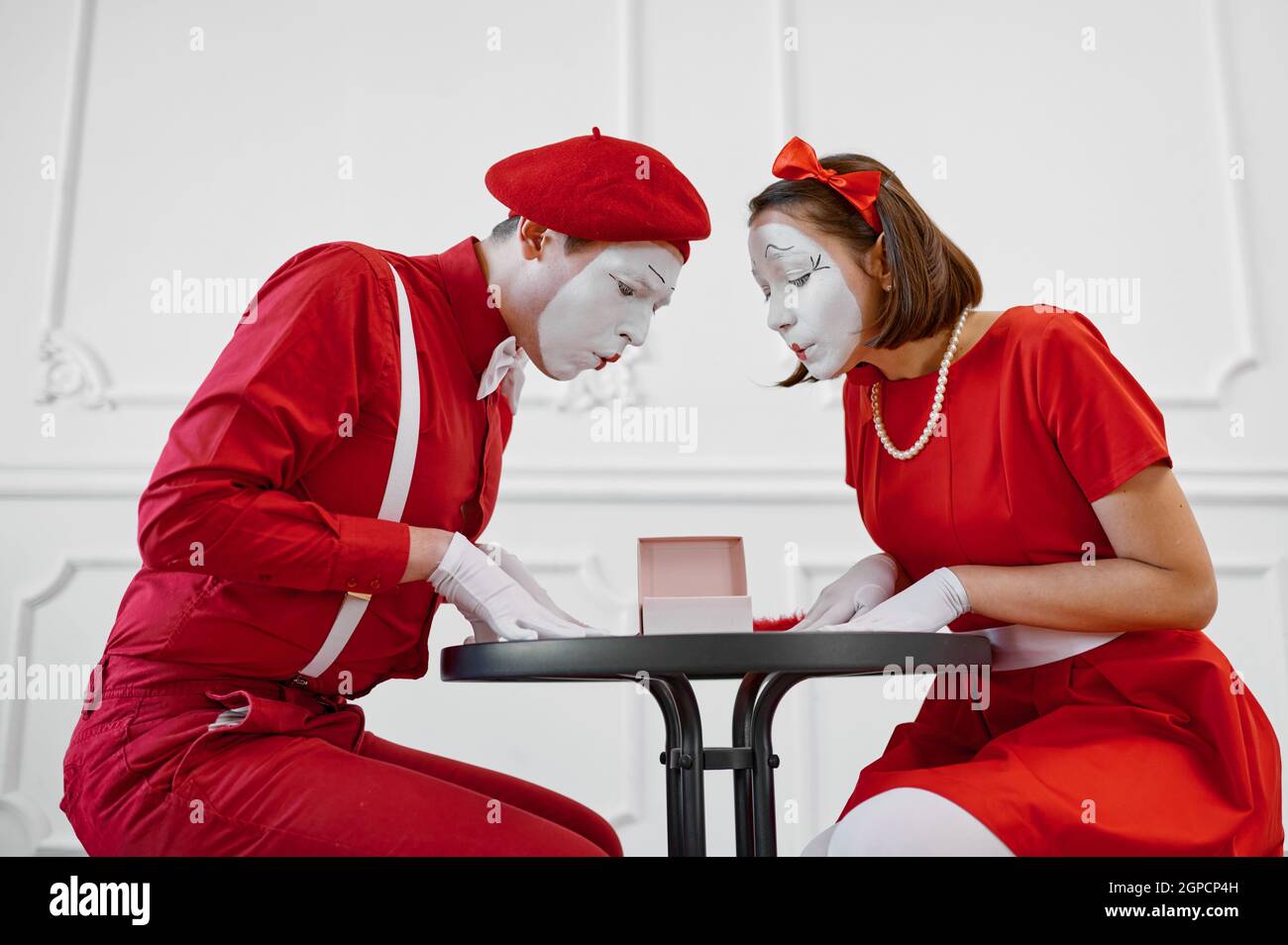 Male and female mime artists are looking on gift. Pantomime theater ...