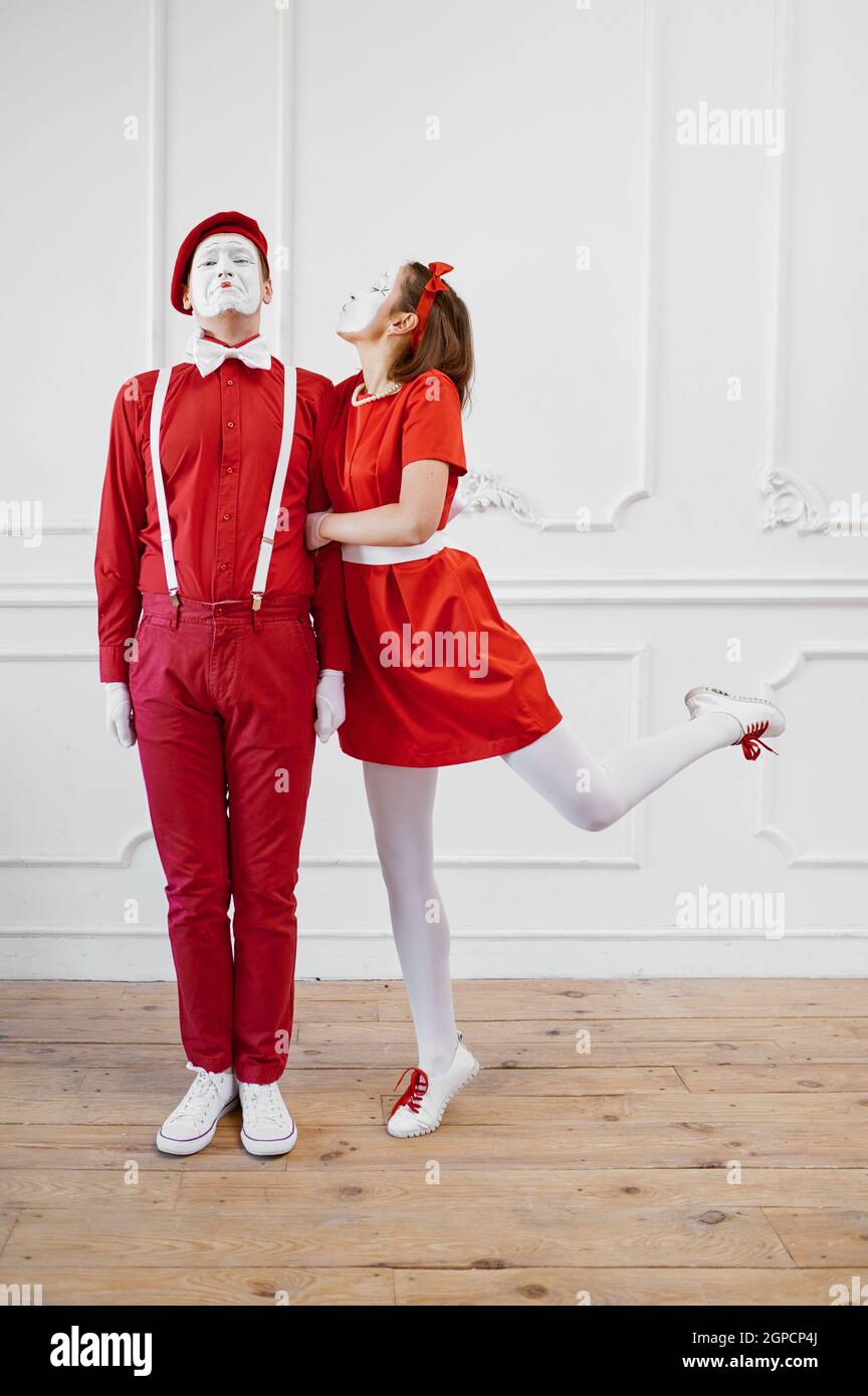 Two mime artists in red costumes, kissing scene. Pantomime theater ...
