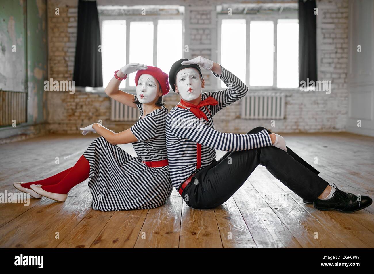 Male and female mime artists sitting on the floor, love couple parody ...