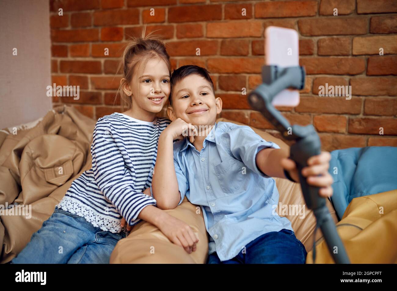 Smiling children bloggers makes selfie on sofa, little vloggers. Kids ...